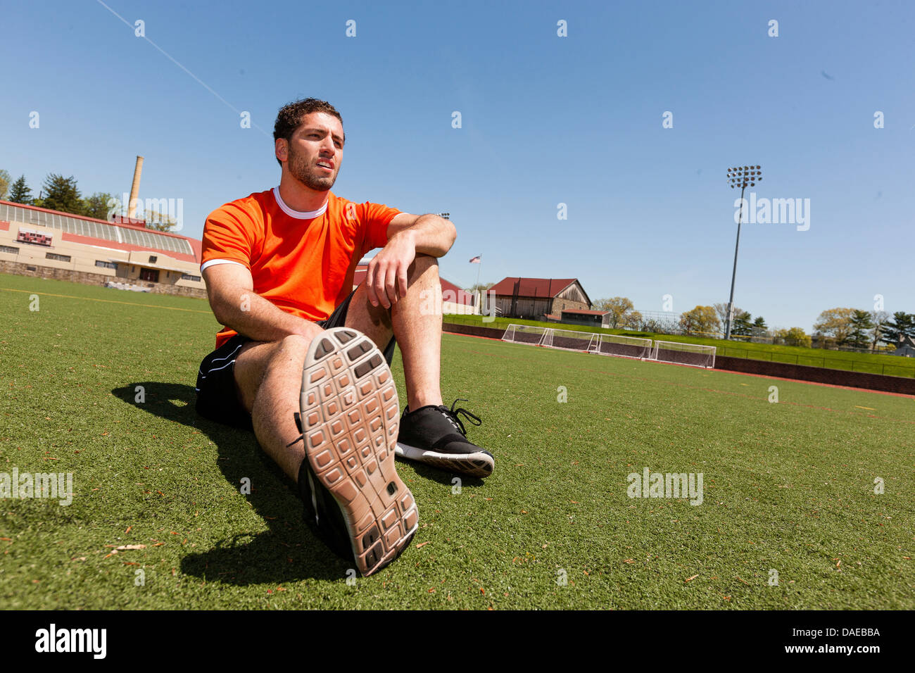 Young man taking a break on sport stadium grass Stock Photo - Alamy