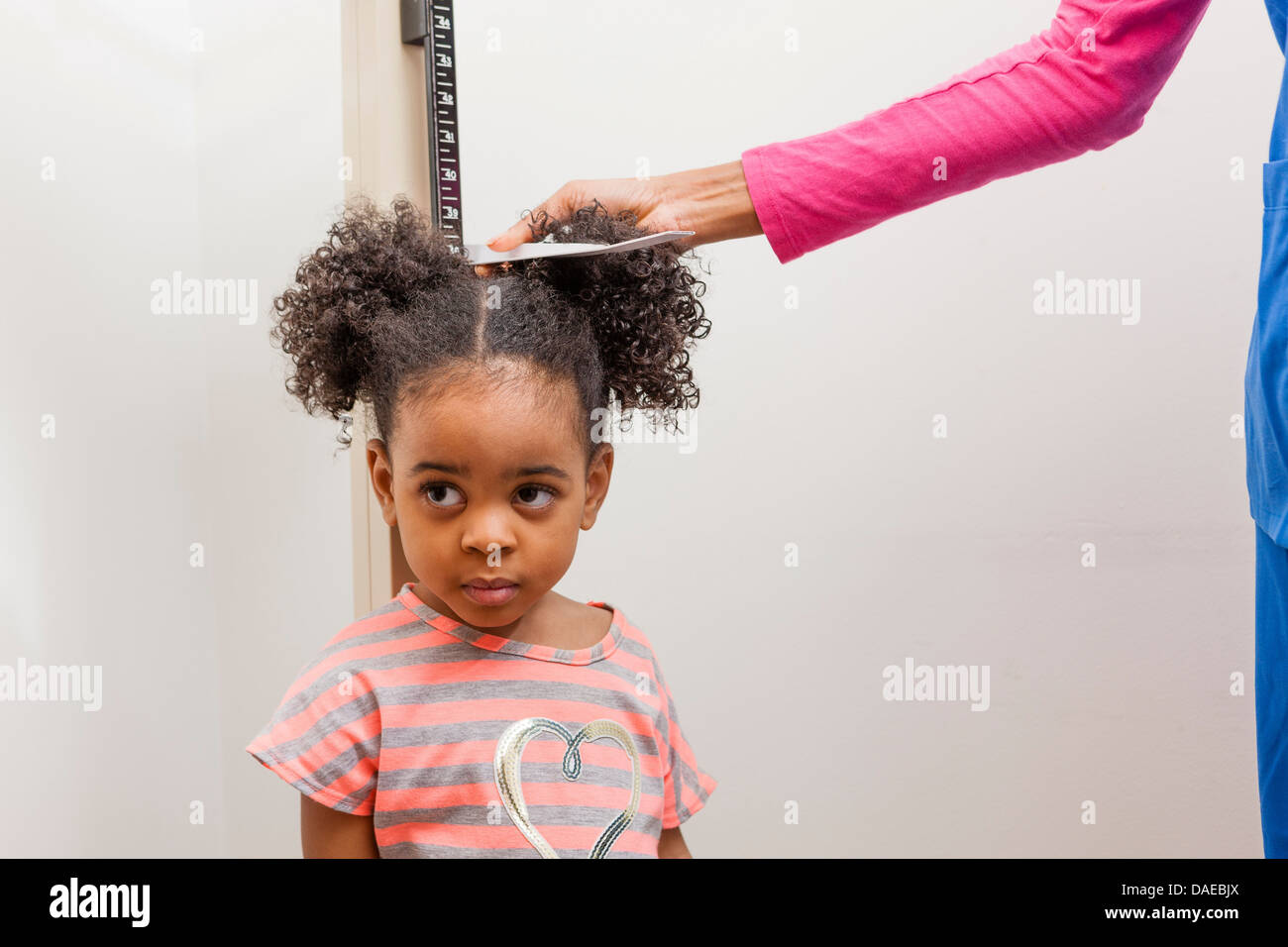 Nurse measuring height of young patient Stock Photo - Alamy