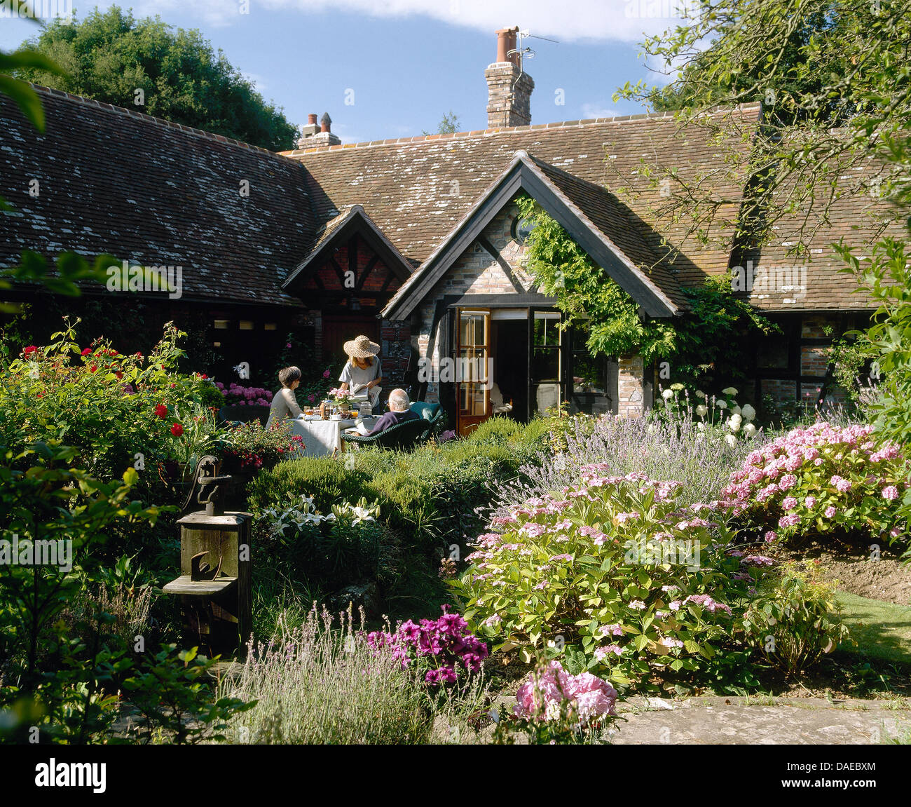 People having lunch on terrace of cottage garden Stock Photo - Alamy