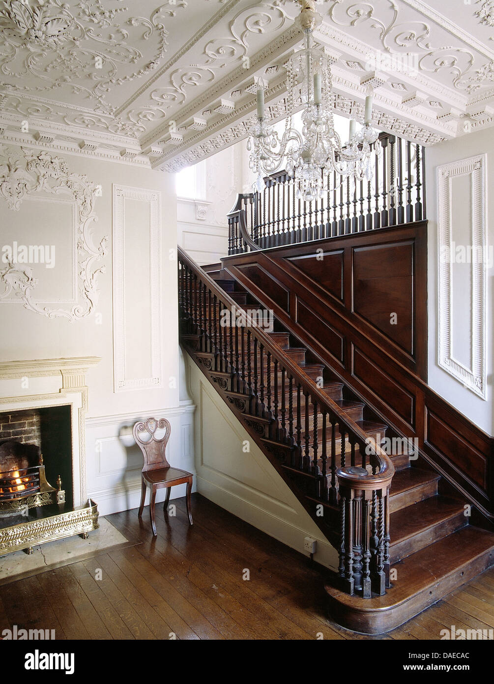 Oak staircase with turned banister in grand hallway with ornate rococo ...