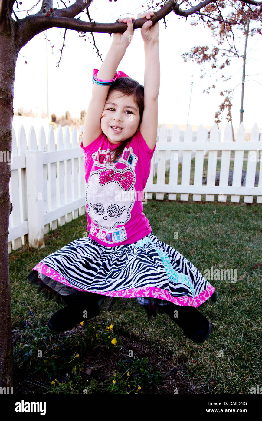 Girl Hanging from Tree Branch Stock Photo - Alamy