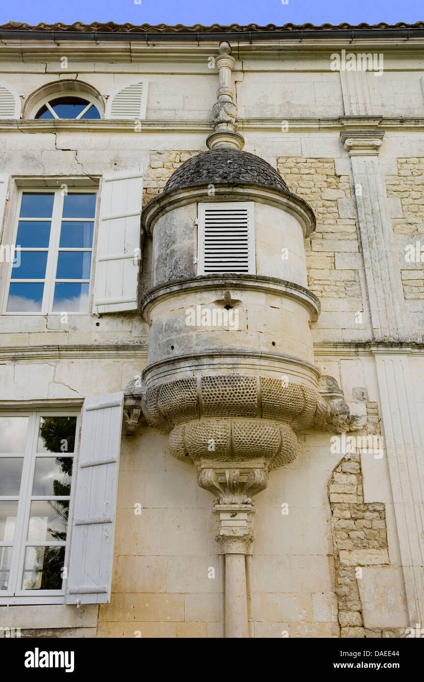 Exterior of French chateau with oriel window beside windows with wooden ...