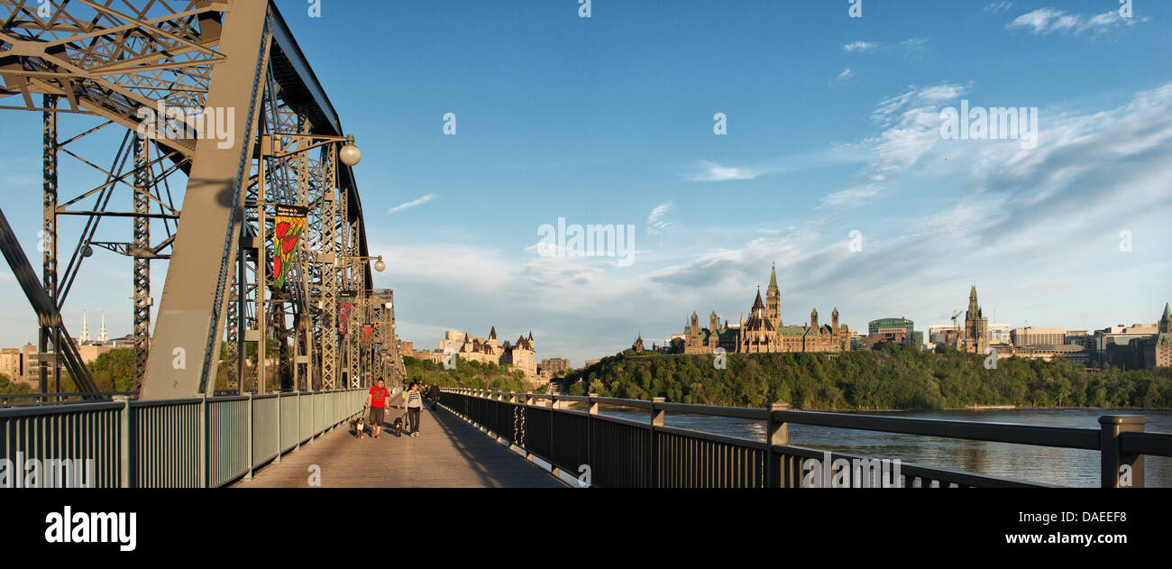 Couple walking with a dog on Alexandra bridge and view of Ottawa ...