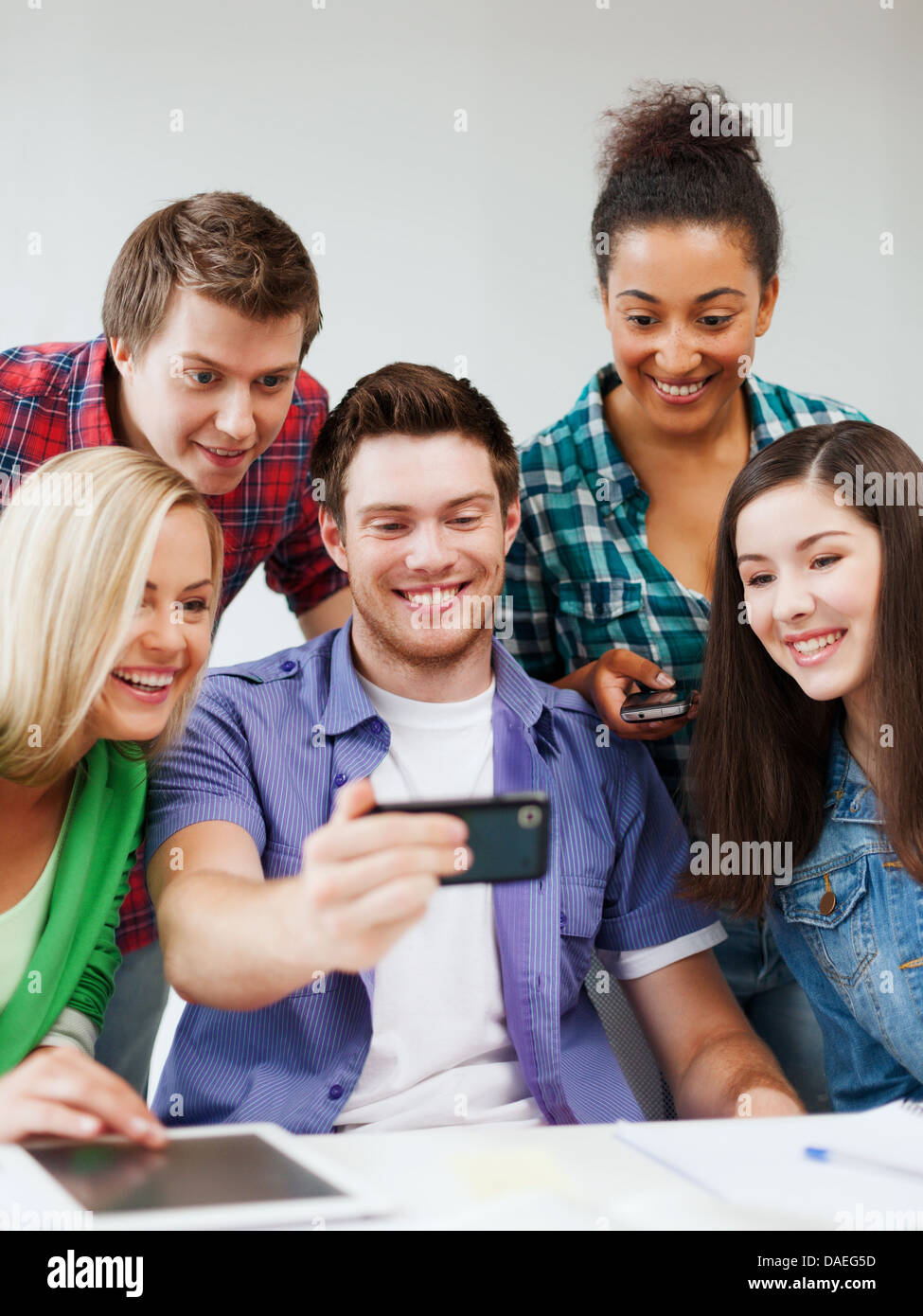 students looking into smartphone at school Stock Photo - Alamy