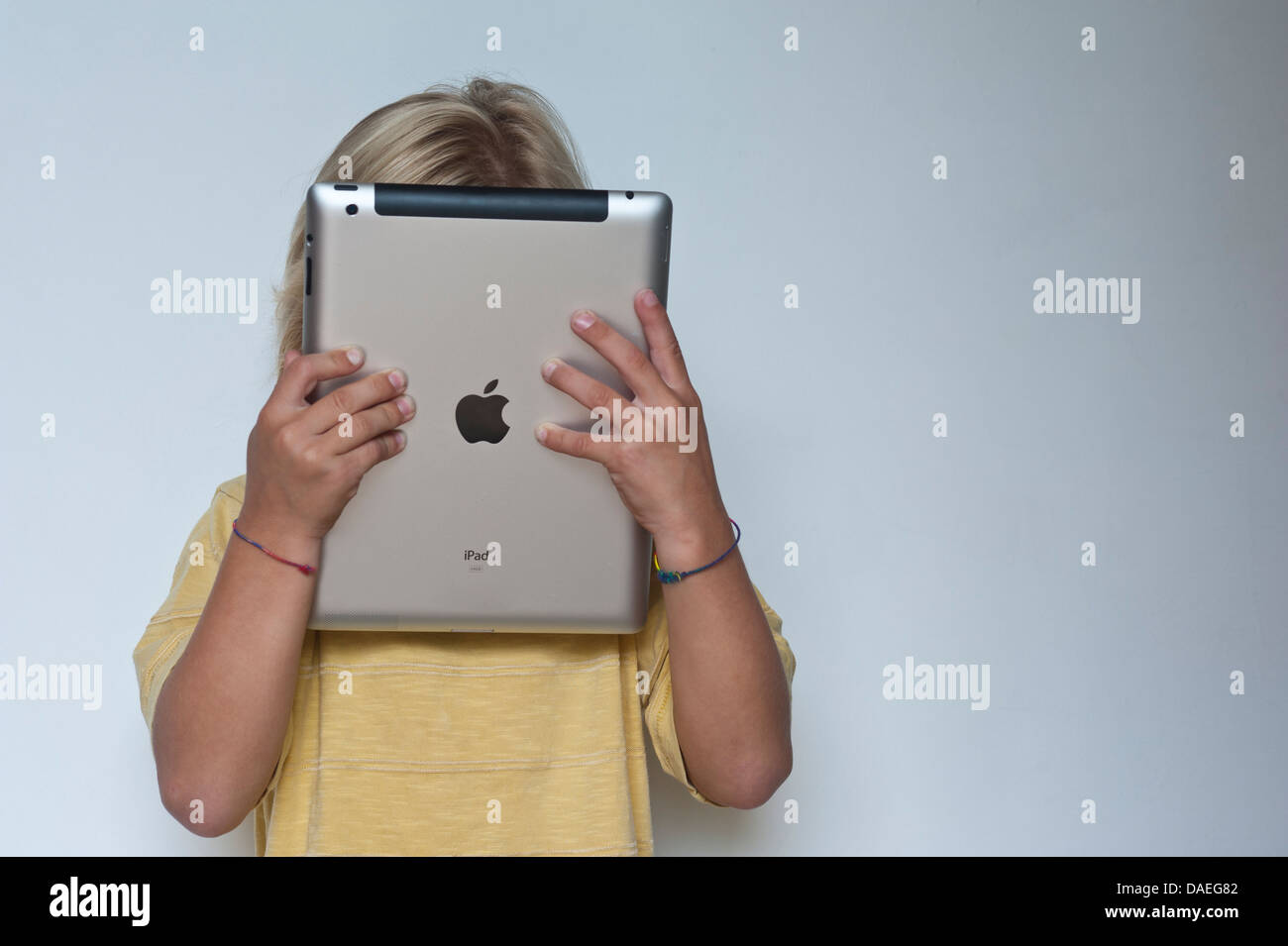 Concept/Infant boy at home with his head buried in his Apple iPad ...