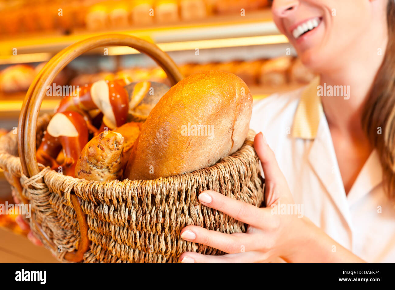 Female baker or saleswoman in her bakery selling fresh bread, pastries ...