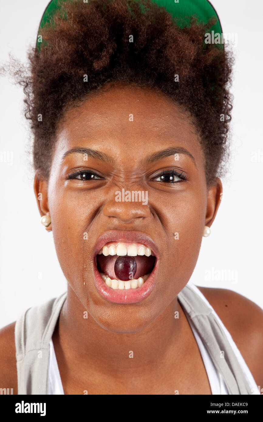 Pretty black woman eating ripe purple grapes with great joy Stock Photo ...