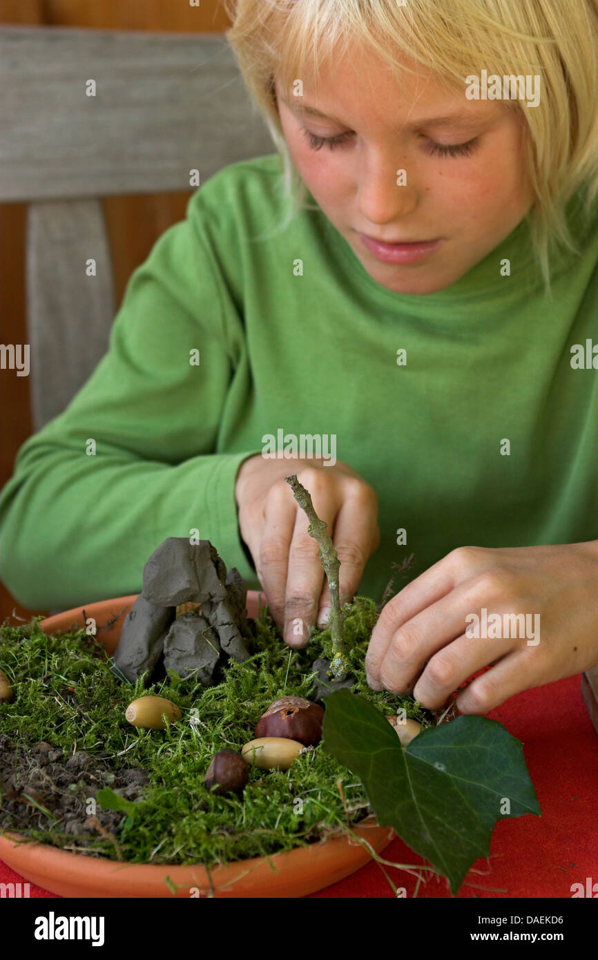 boy tinkering a dwarf garden with nature materials, Germany Stock Photo ...