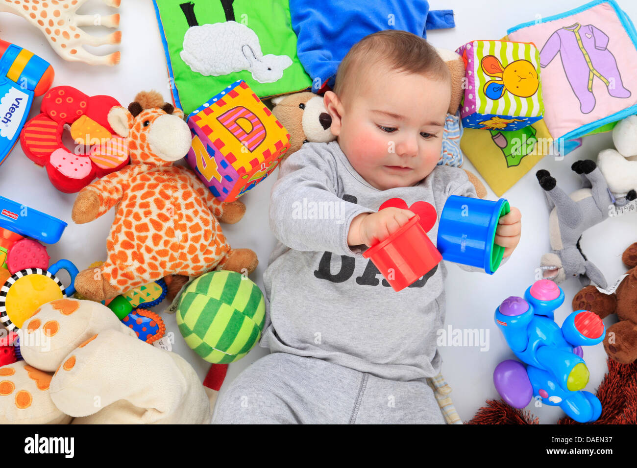 baby lying beween playthings in supine position Stock Photo - Alamy