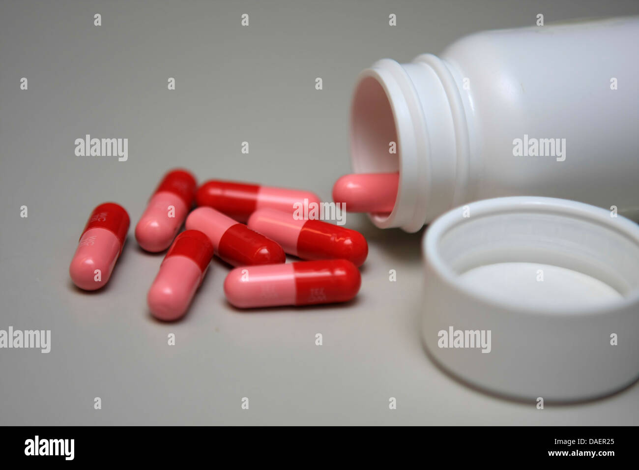 red pink pills spilling out of white bottle medicine, drug, drugs Stock ...