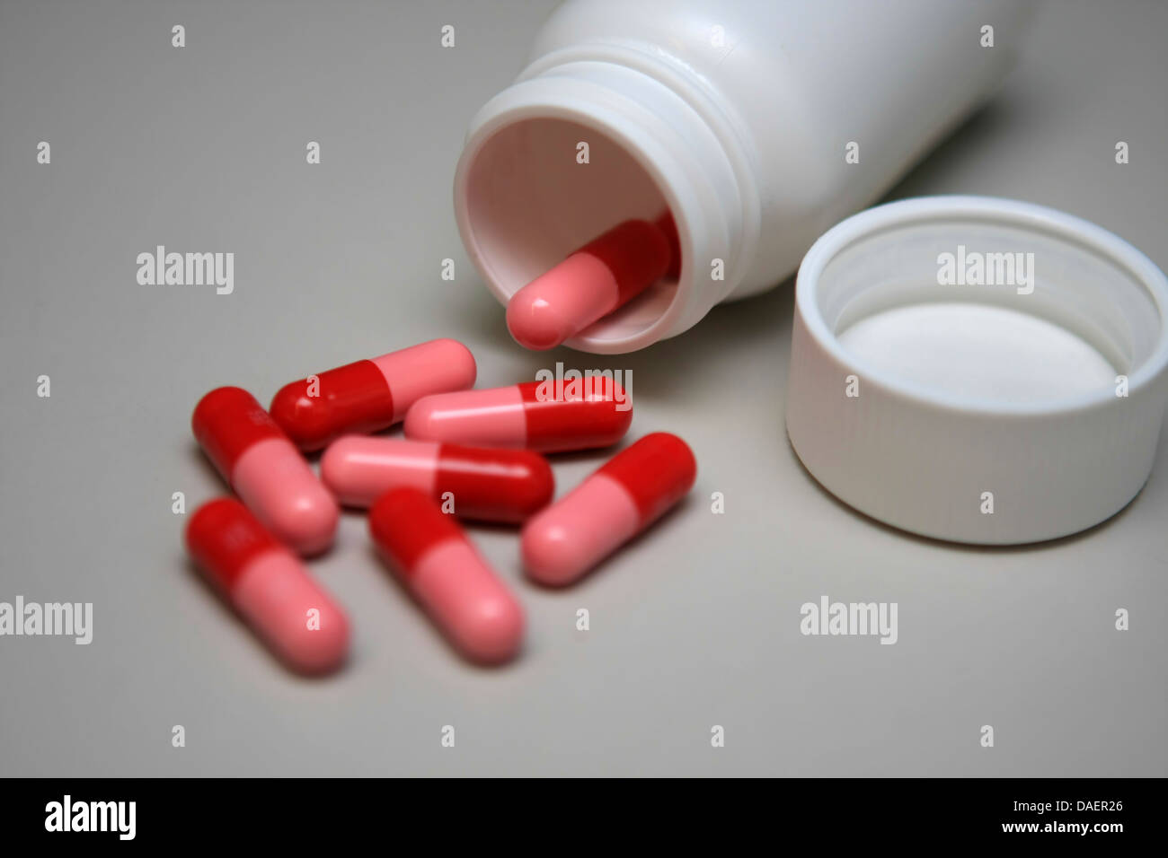 red pink pills spilling out of white bottle medicine, drug, drugs Stock ...