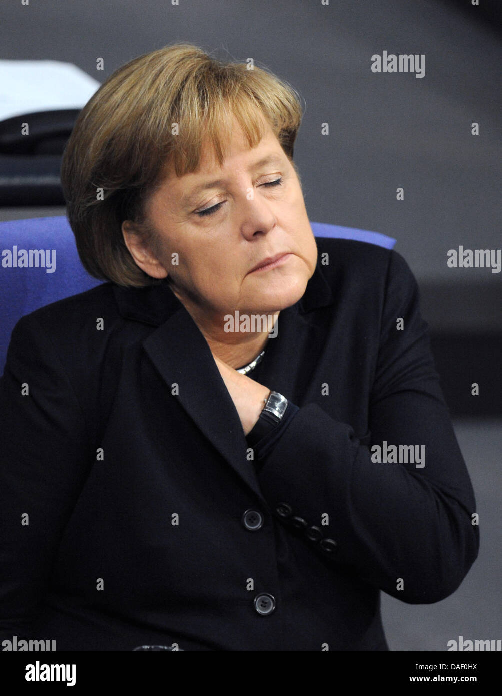 German Chancellor Angela Merkel (CDU) touches her shoulder at the ...