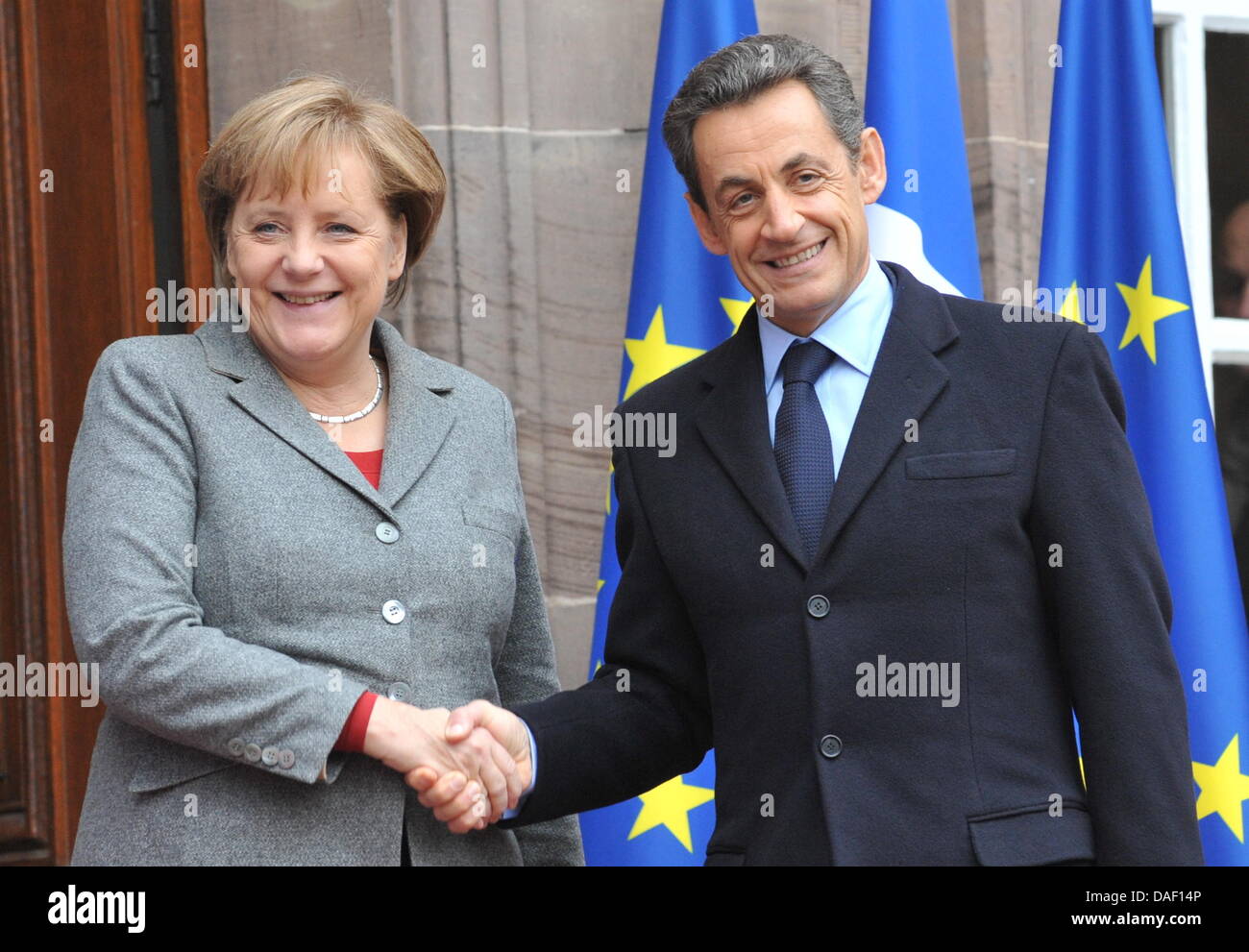 French President Nicolas Sarkozy (R) shakes hands with German ...