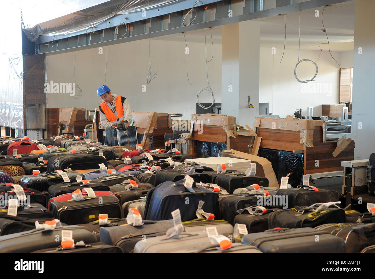 Construction workers bring test luggage for check-in at the new BER ...