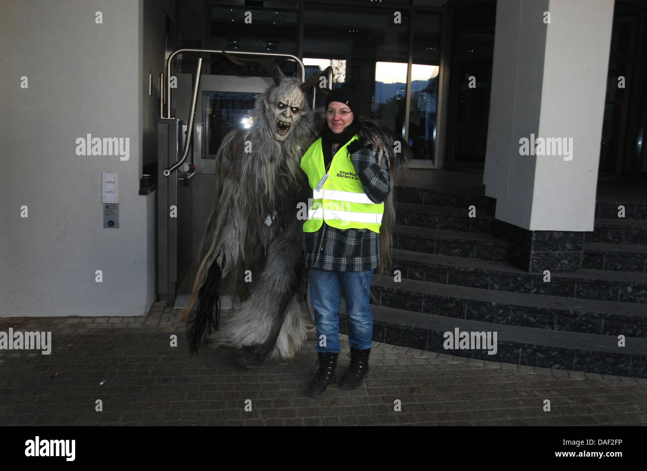 A winter fool, also known as Klausen, embraces an organiser (R) during ...