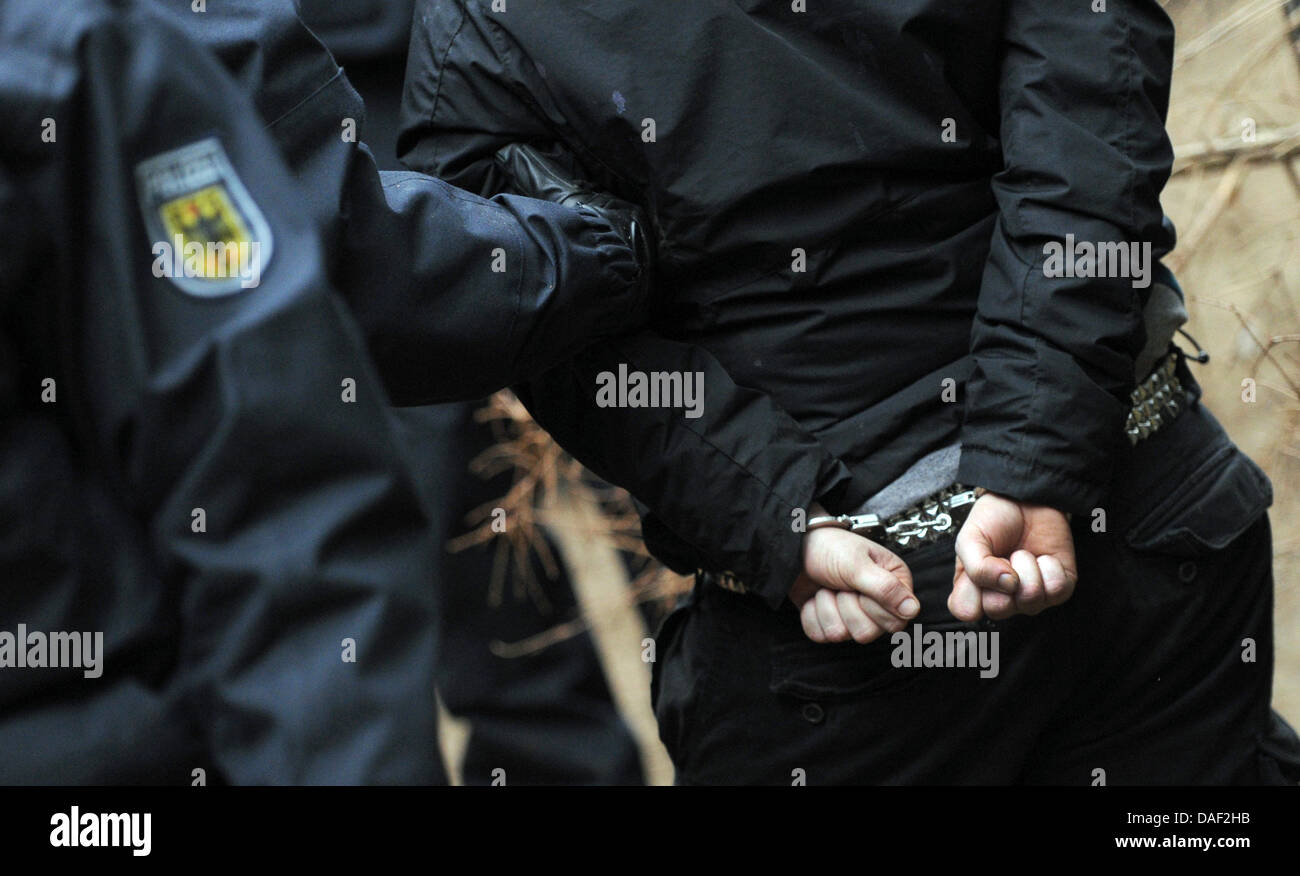 A female anti-nuclear activist (R) is hand-cuffed after being arrested ...