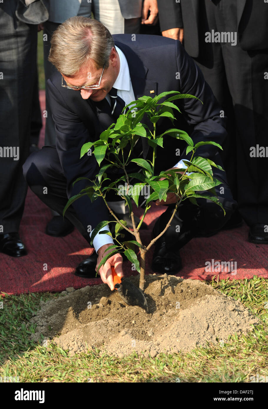 German President Christian Wulff plants a mango tree at the national ...