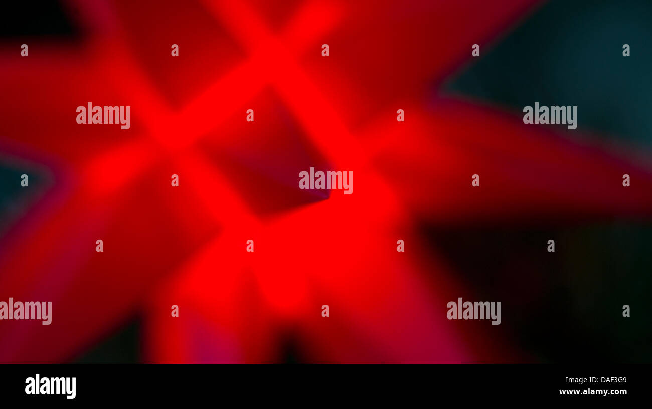 A red Moravian star hangs on a colorfully decorated Christmas tree in ...