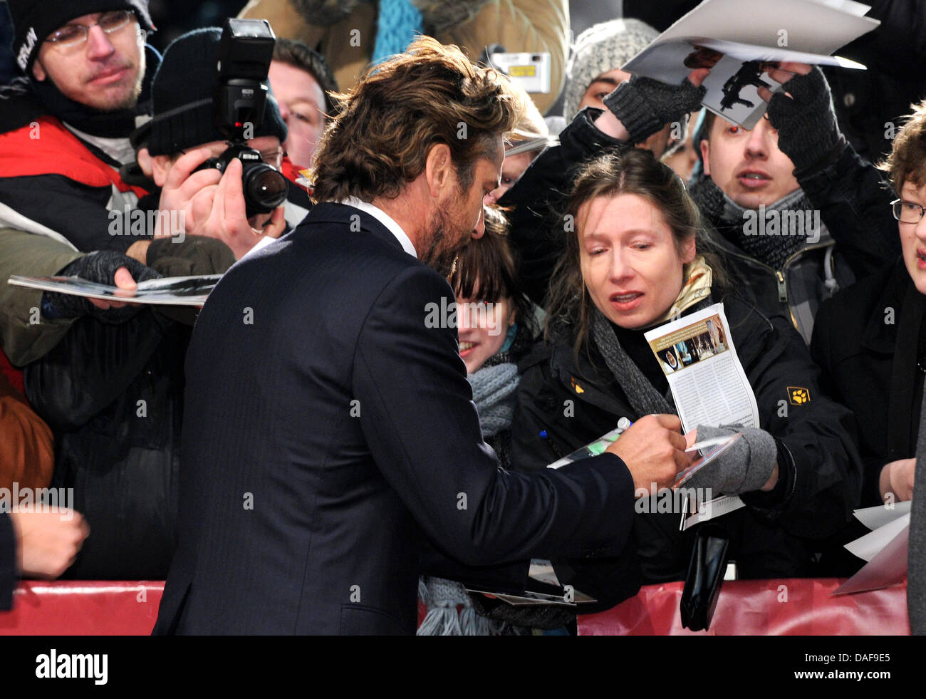 Scottish actor Gerard Butler signs autographs as he arrives for the ...