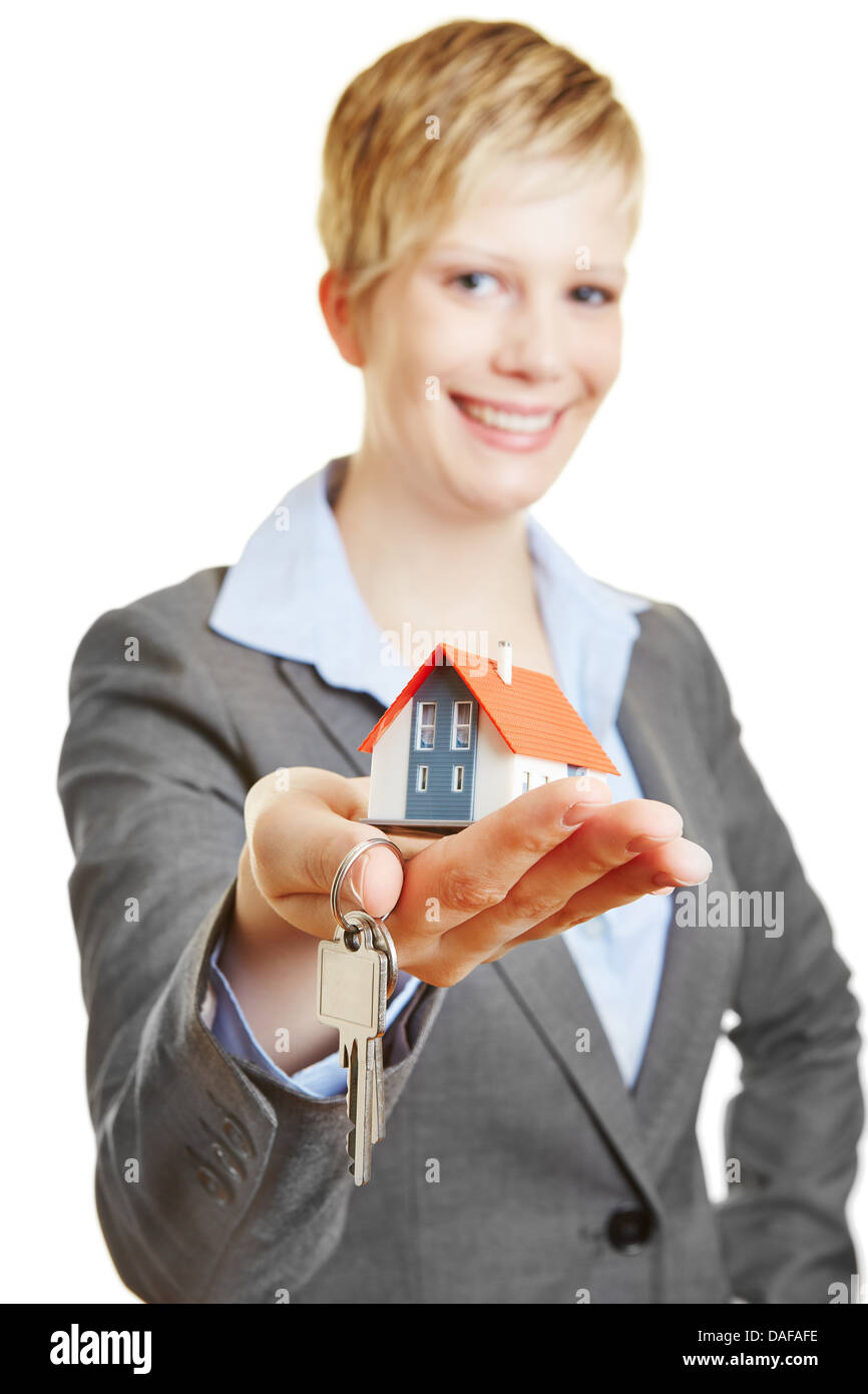 Smiling property broker with a small house and keys Stock Photo - Alamy
