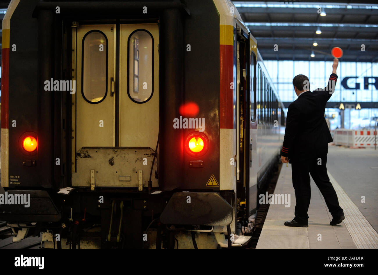 A train guard signals 'go' in Munich, Germany, 22 February 2011. German ...