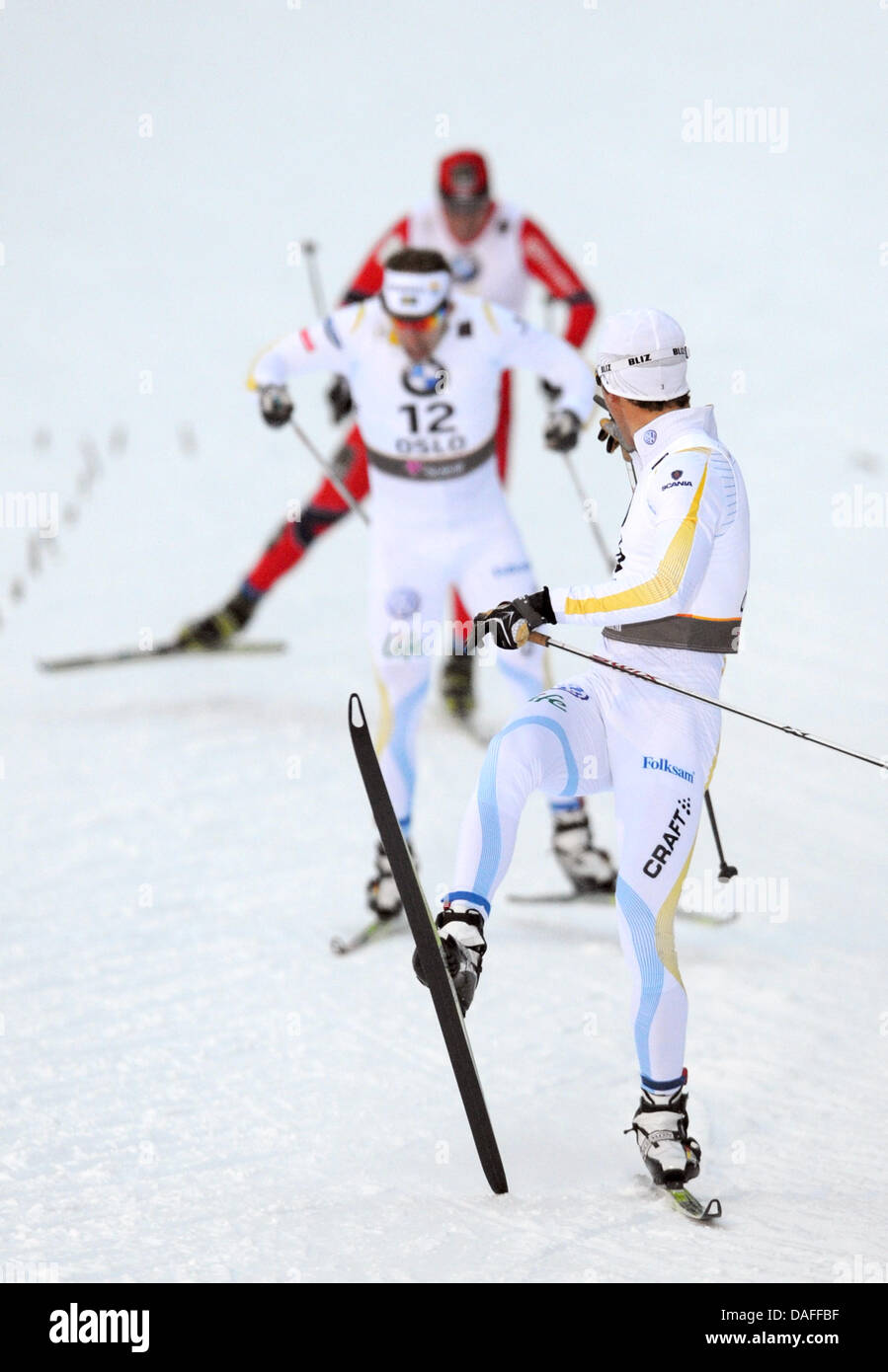 Marcus Hellner of Sweden (R, 1st place) points to his compatriot team ...