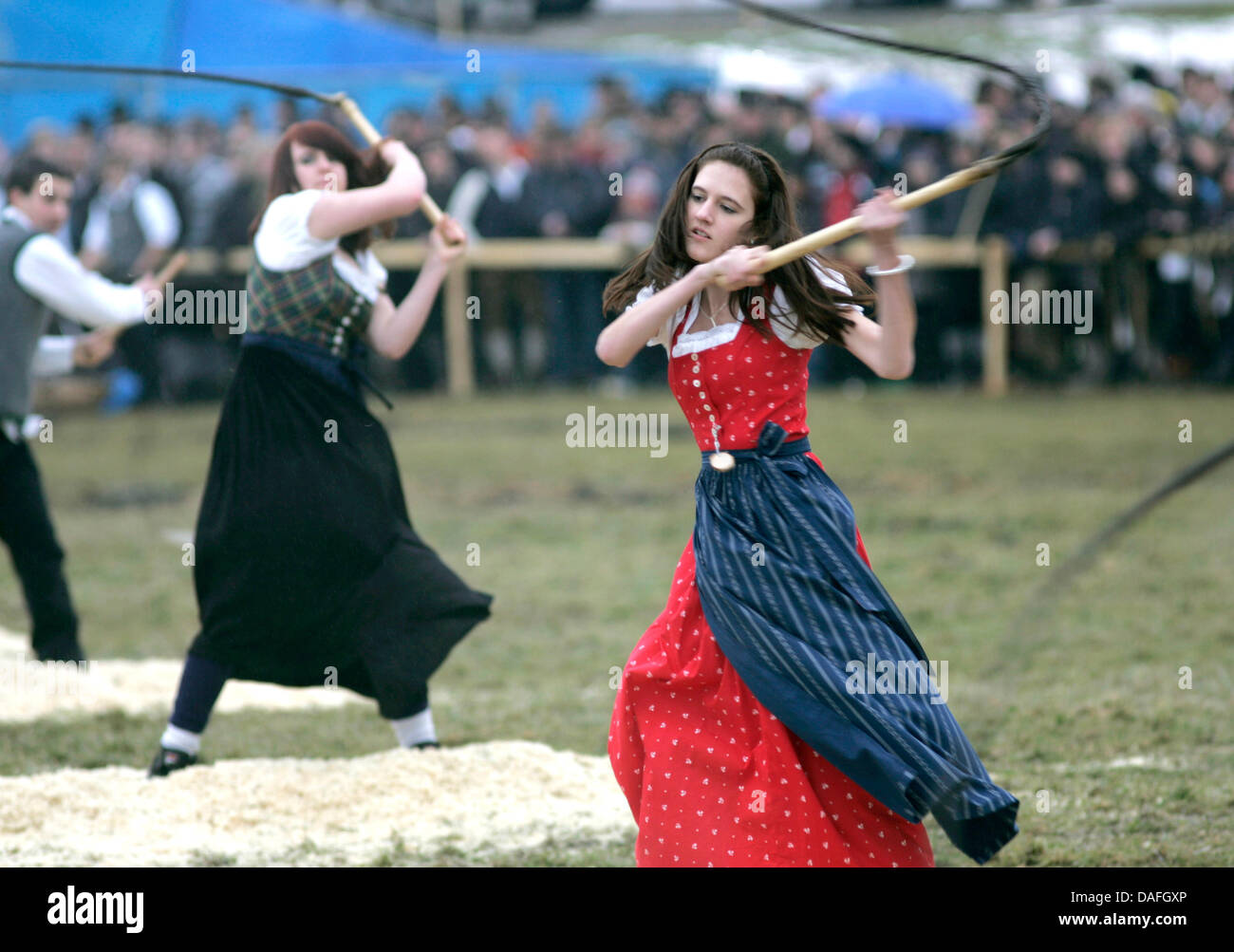 People in traditional Bavarian costumes take part in the whip challenge ...