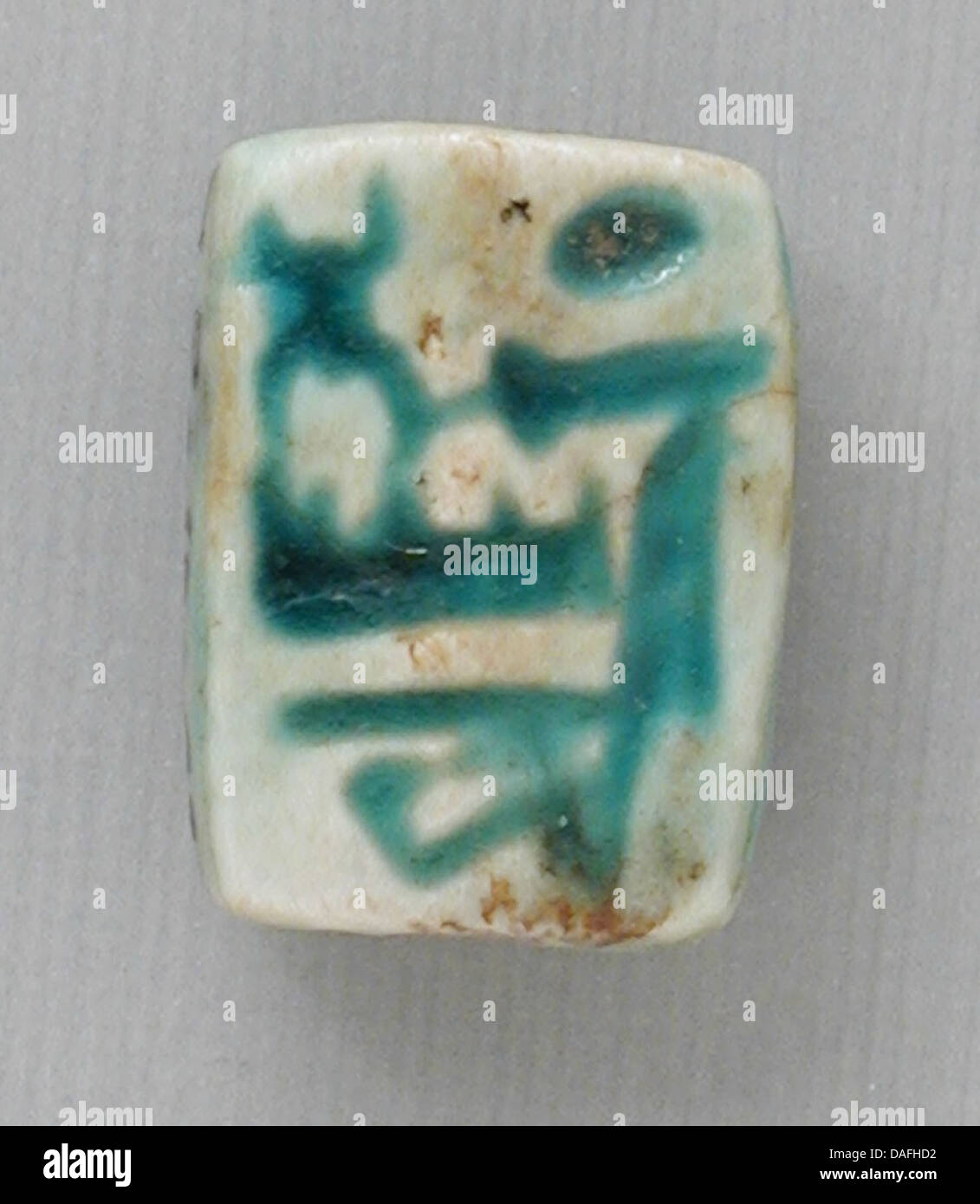 A faience amulet bearing the name of Amen-Re, an ancient Egyptian deity ...