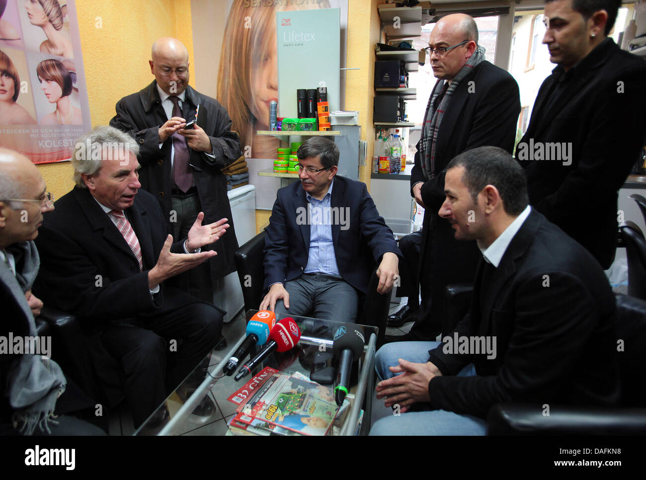 Turkish Foreign Minister Ahmet Davutoglu (C) talks to the owner of the ...