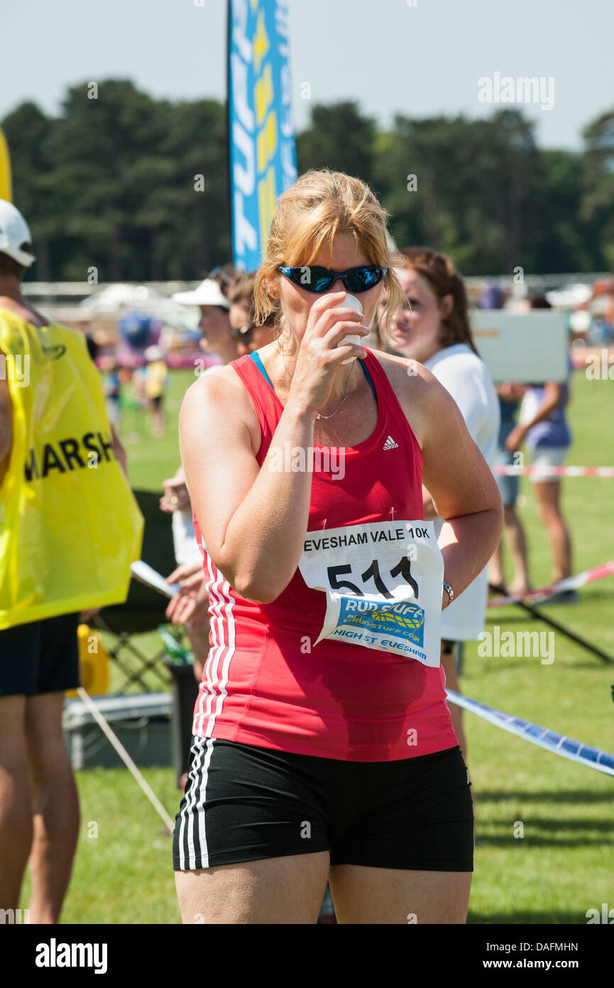 Female runner drinks cold water to recover at end of race, Evesham ...