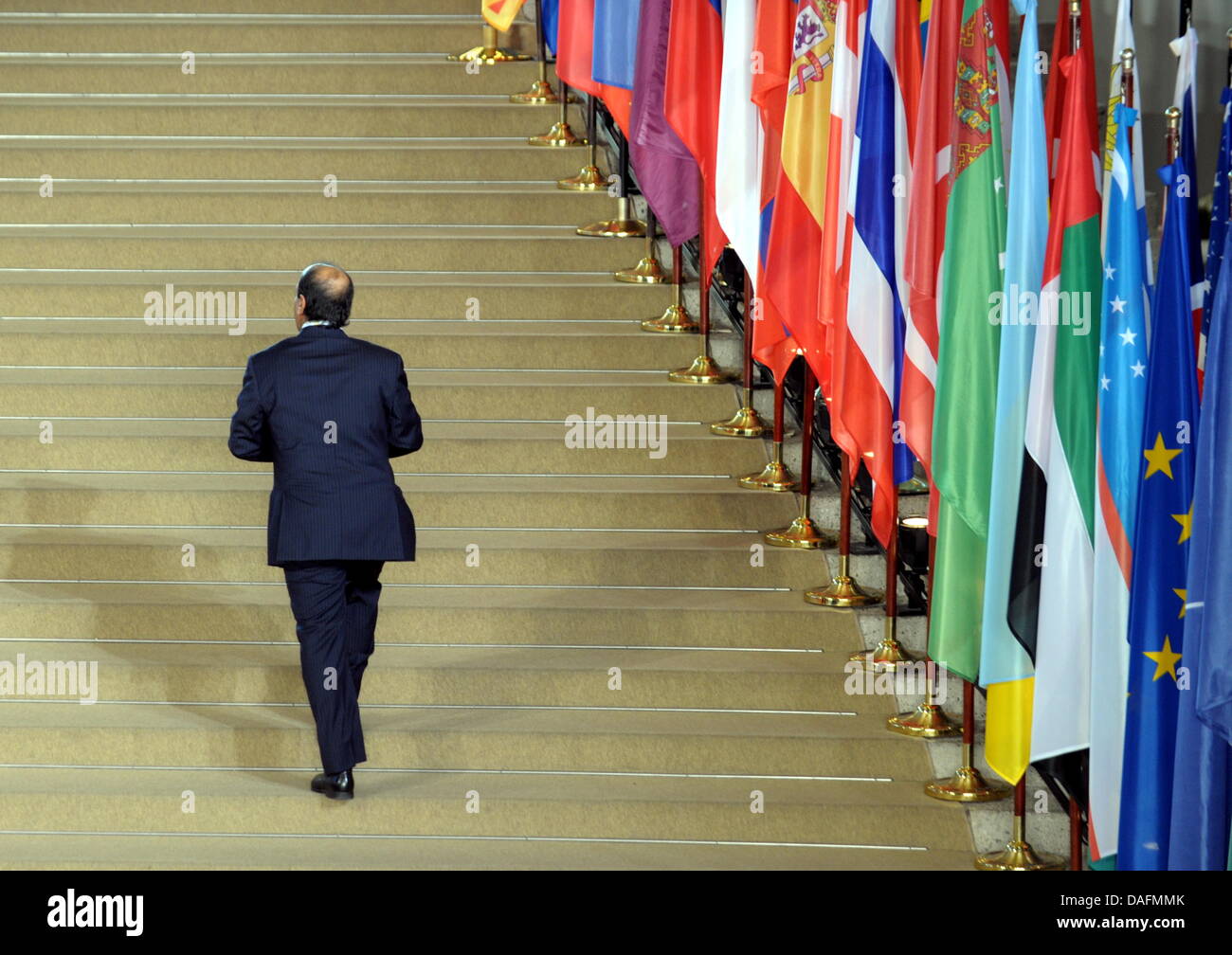 A delegate walks past flags during the International Afghanistan ...