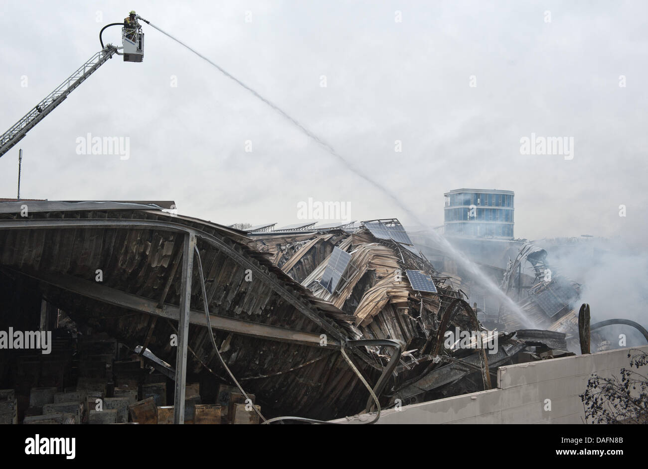 Firefighters extinguish a fire at a completely burnt out warehouse in ...