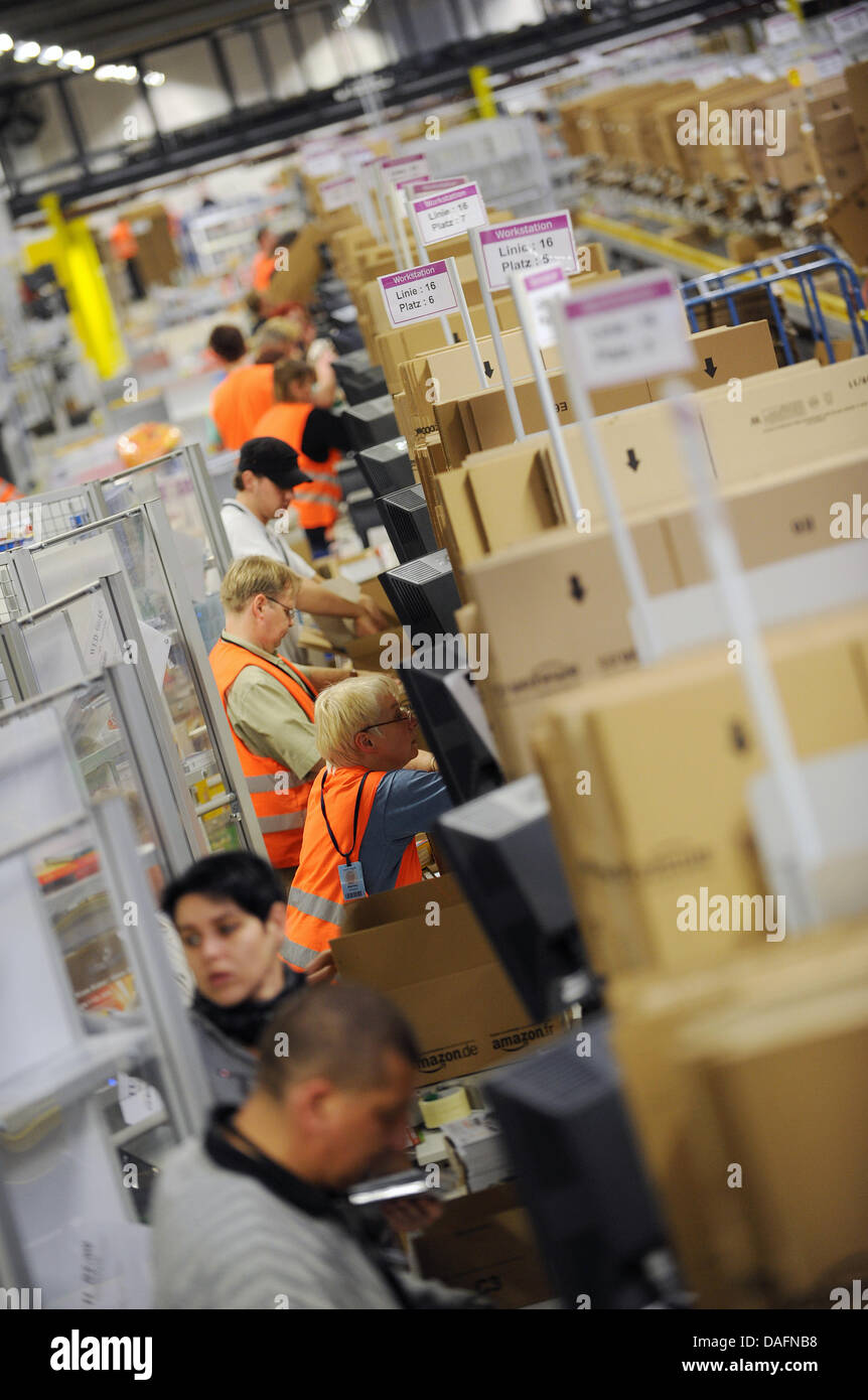 Employees of the online retailer Amazon pack goods at the logistics ...