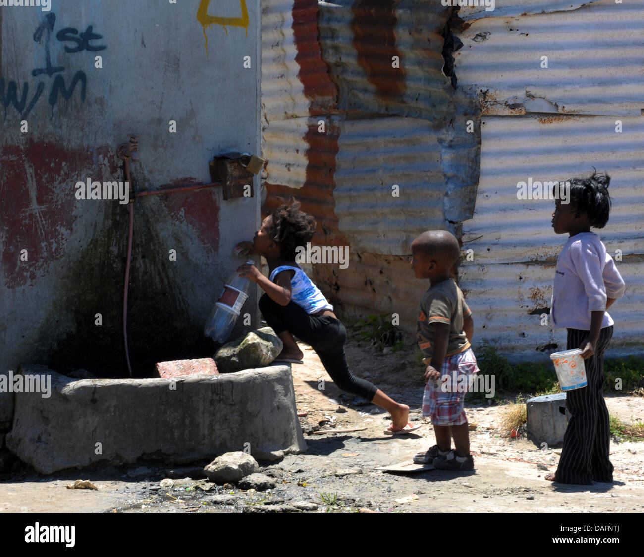 Children stands at a public watering place in township Philippi near ...