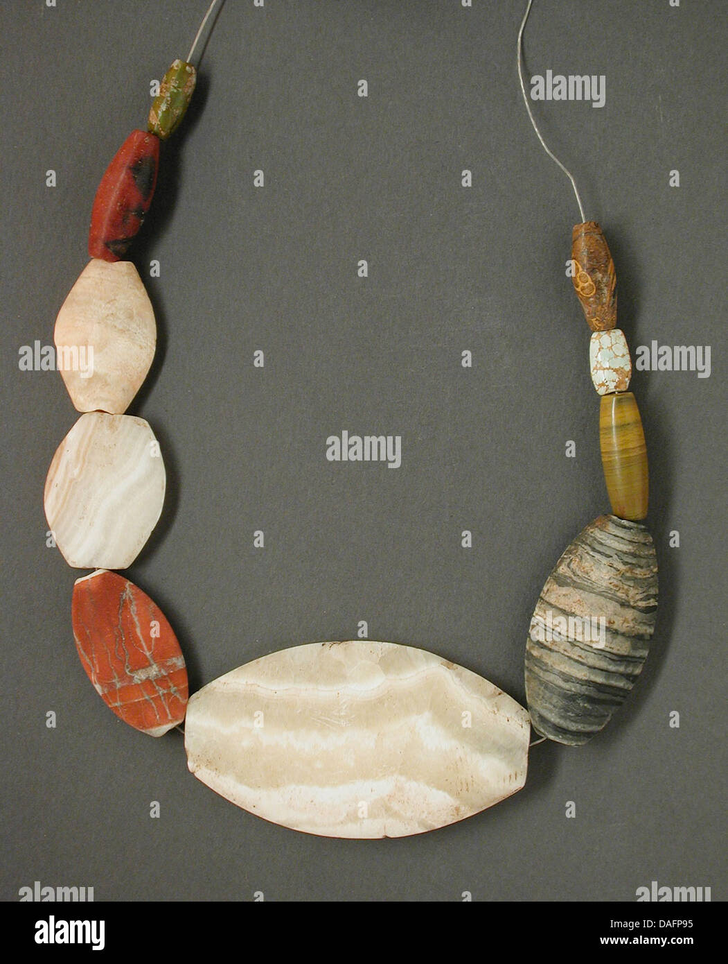 This group of beads, crafted in various materials, showcases ancient ...
