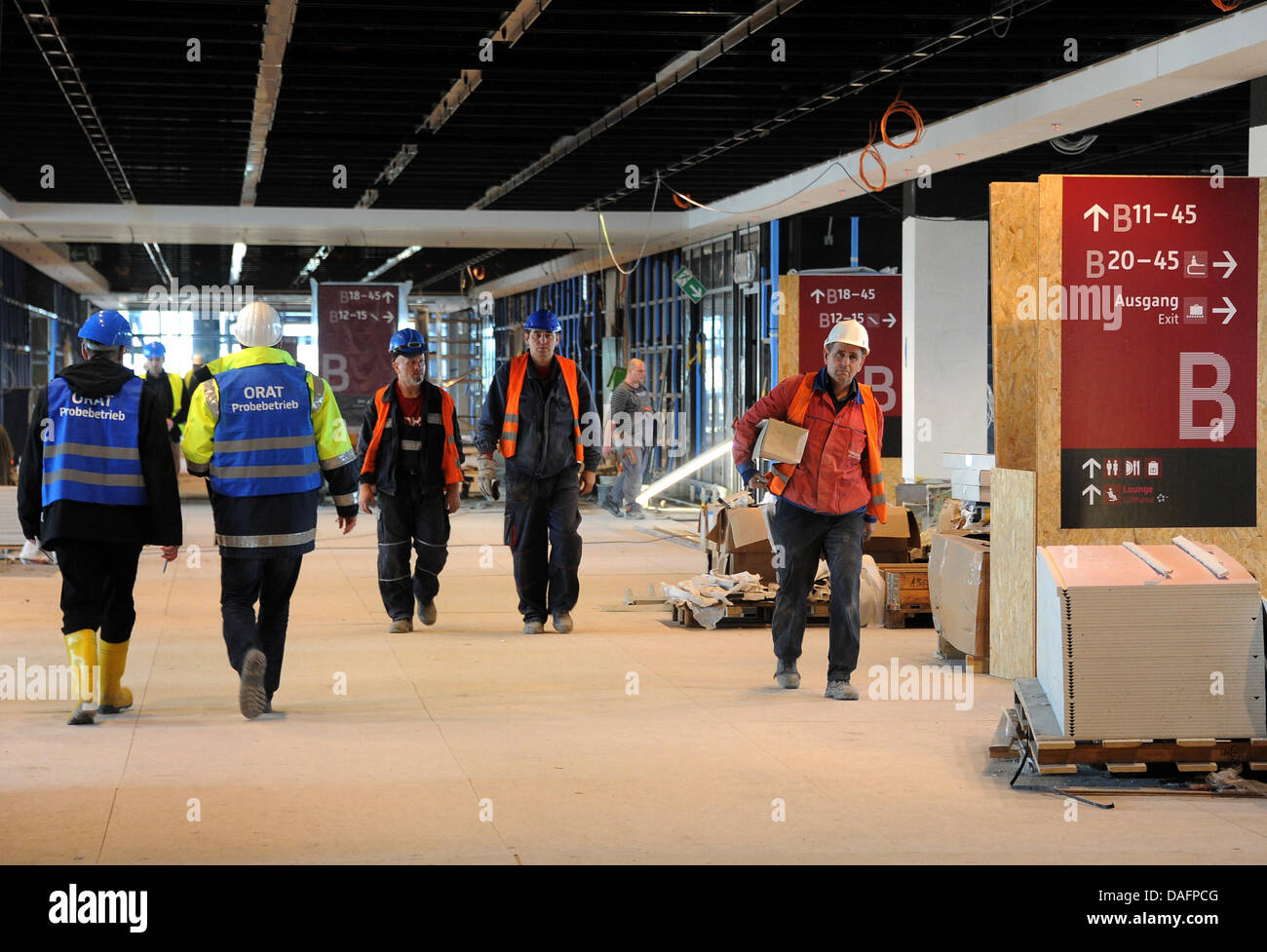 Test passengers walk through the main pier to one of the gates during a ...