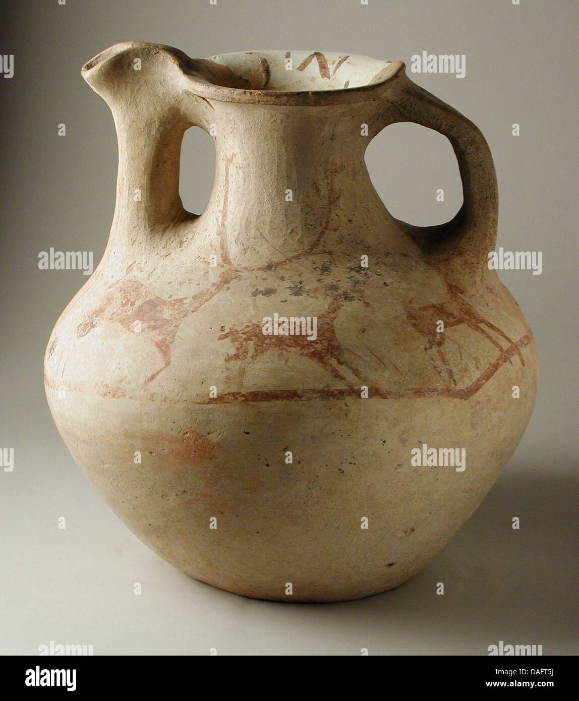 This ancient jug features a vertical spout and is crafted for ...