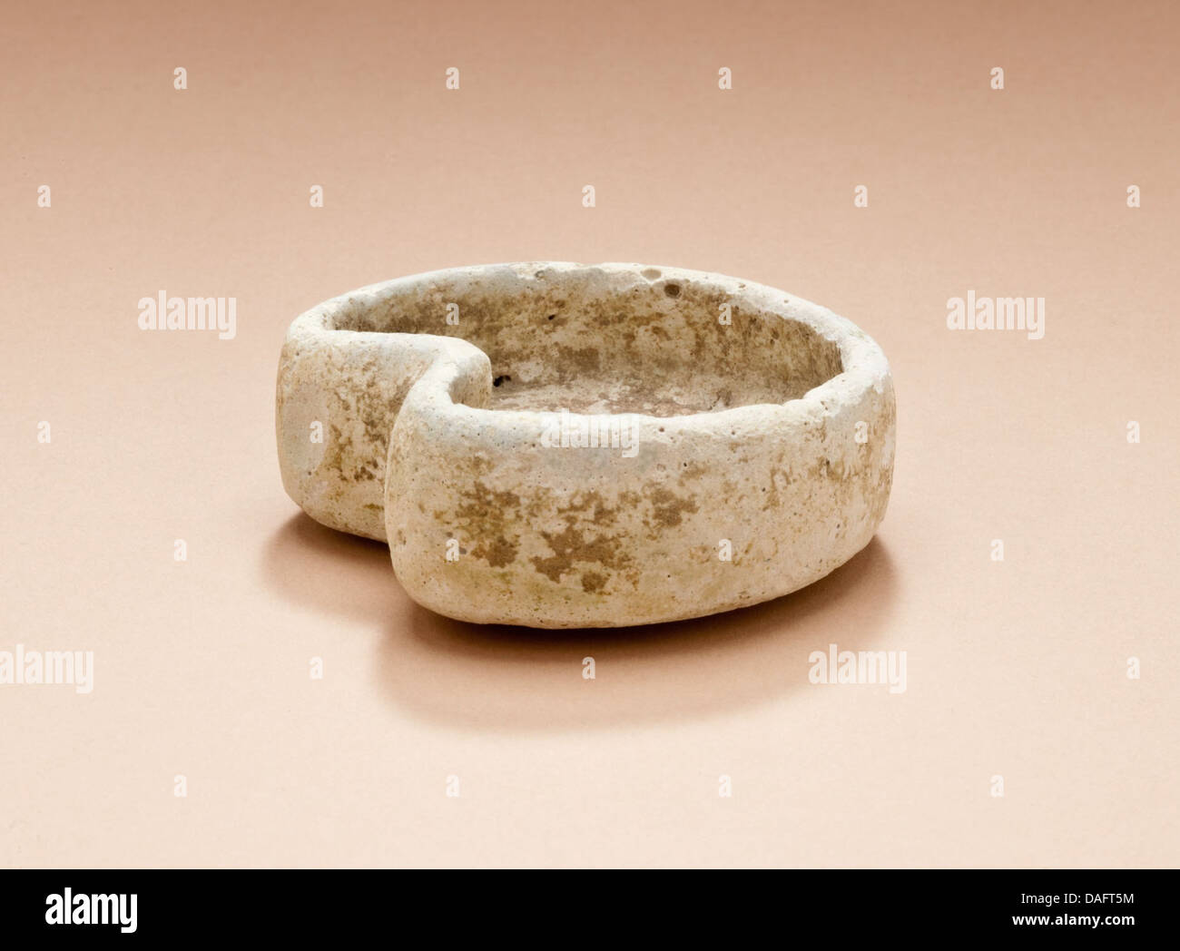 This kidney-shaped dish, crafted from metal and ceramic materials, is ...
