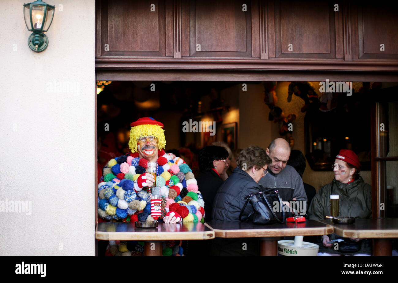 A carnevalist dressed as clown is pictured at a bar in Cologne, Germany ...