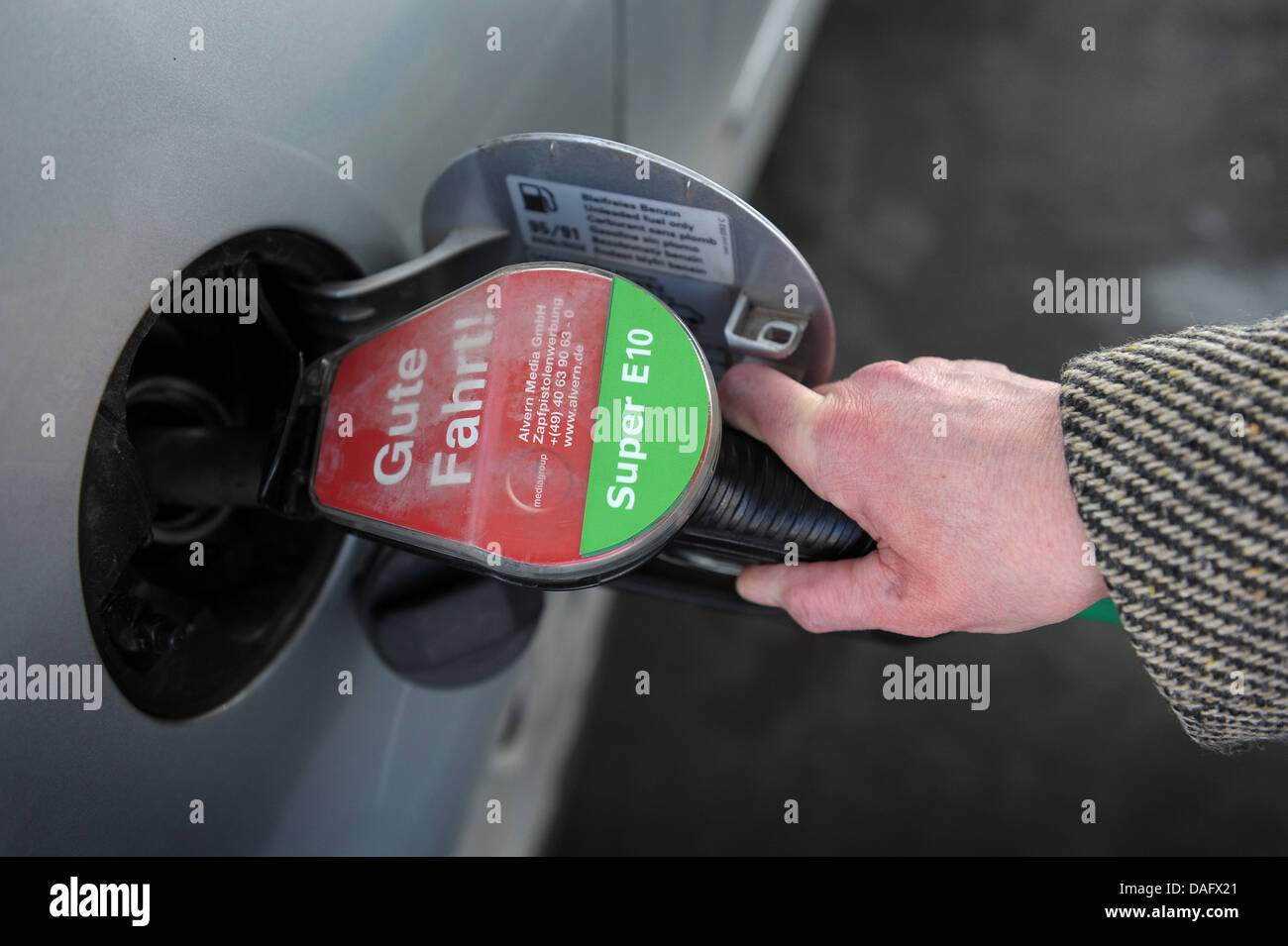 A woman tanks up her vehicle with biofuel E10 at a petrol station in ...