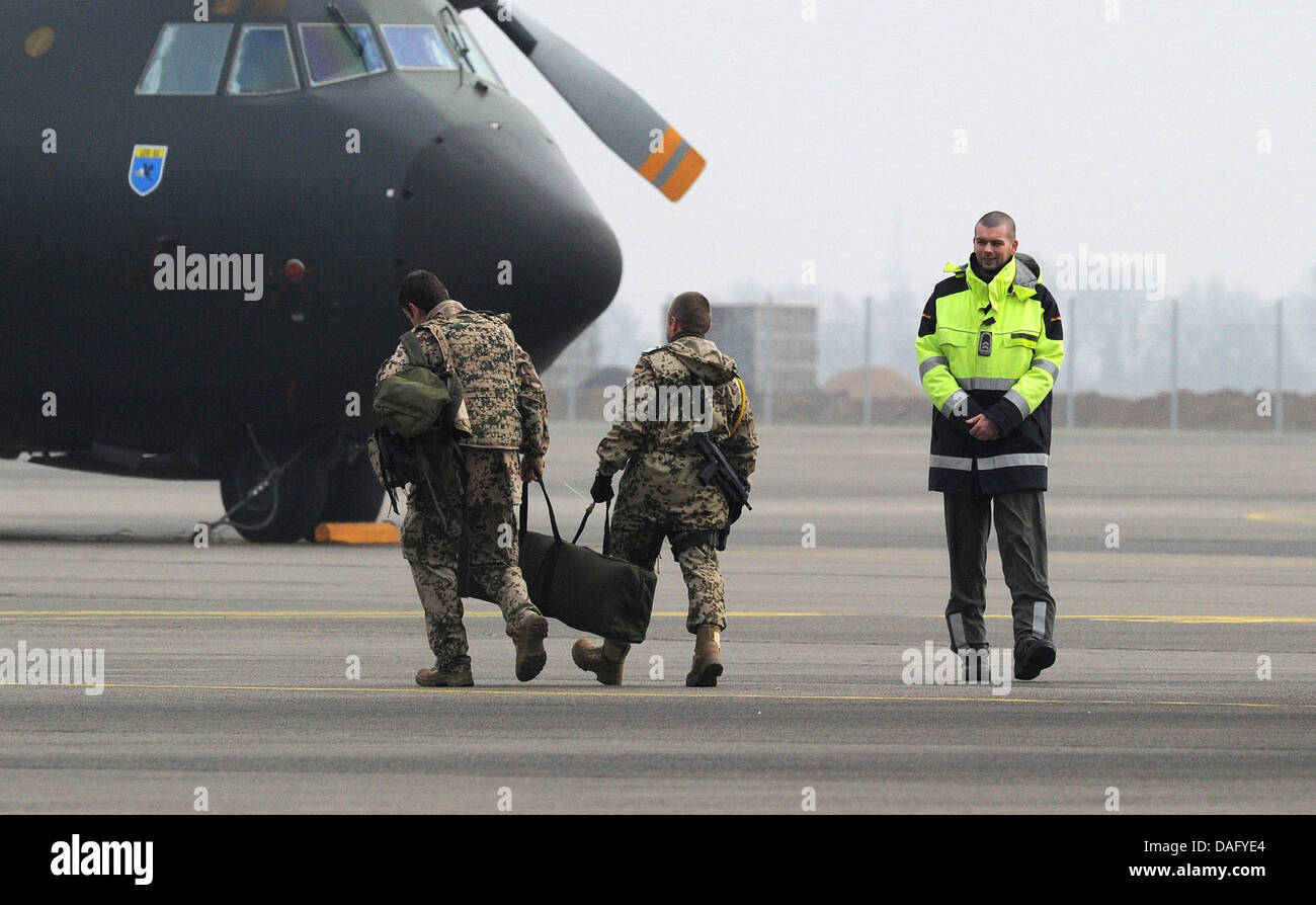 Two German Bundeswehr soldiers carry a bag as they board a Transall at ...