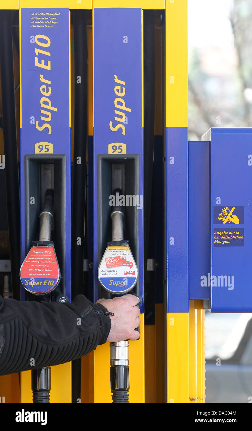 A hand grabs the petrol pump nozzle providing 'biofuel' Super E10 in ...