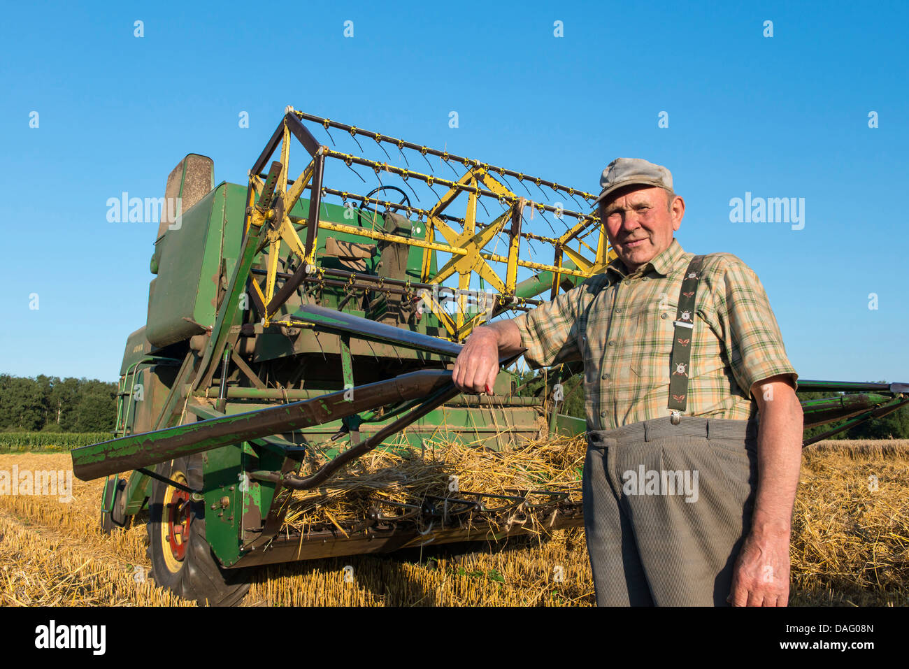 farmer in front of his old combine harvester in grain field, Germany ...