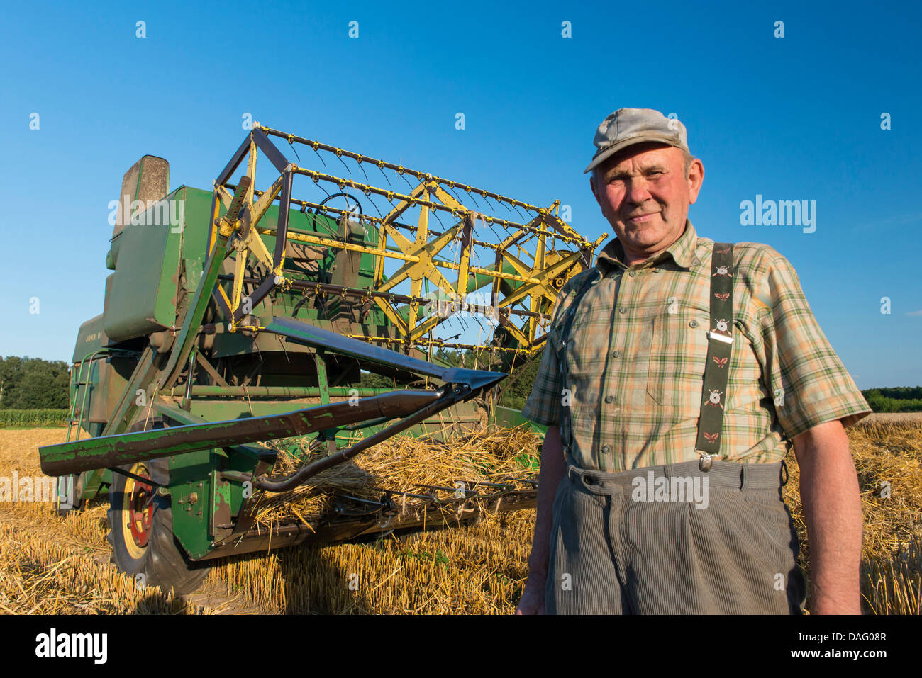 farmer in front of his old combine harvester in grain field, Germany ...
