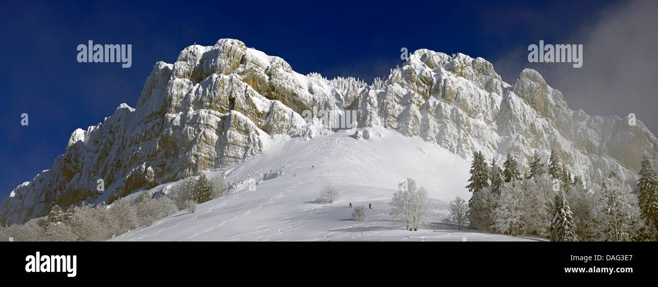 ski slope in front of a rock wall and clear blue sky at the pass of the ...