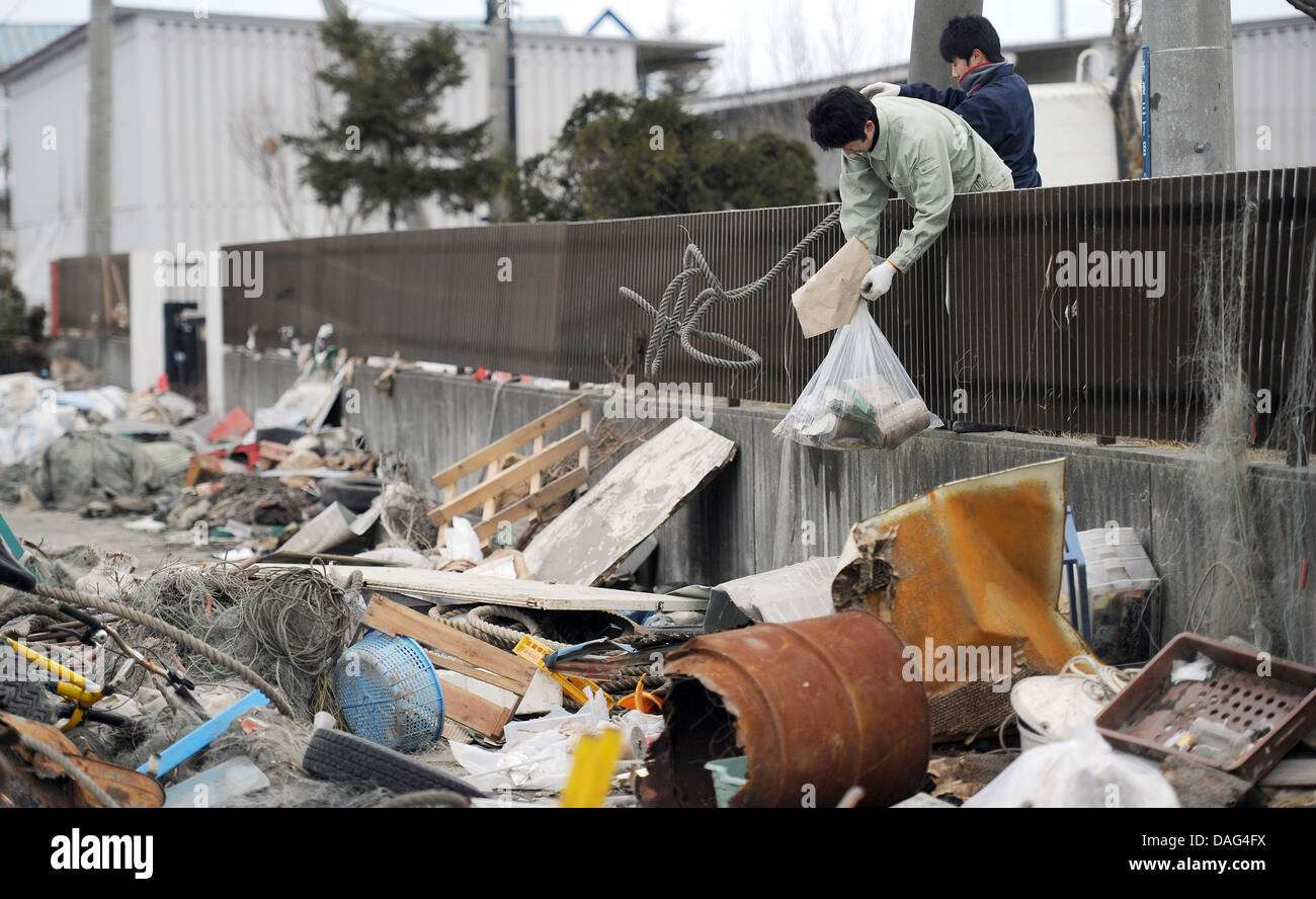 People remove debris from the harbour of Hachinohe, Japan, 18 March ...