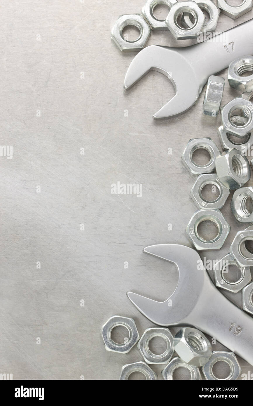 wrench and nut tool on metal background texture Stock Photo - Alamy
