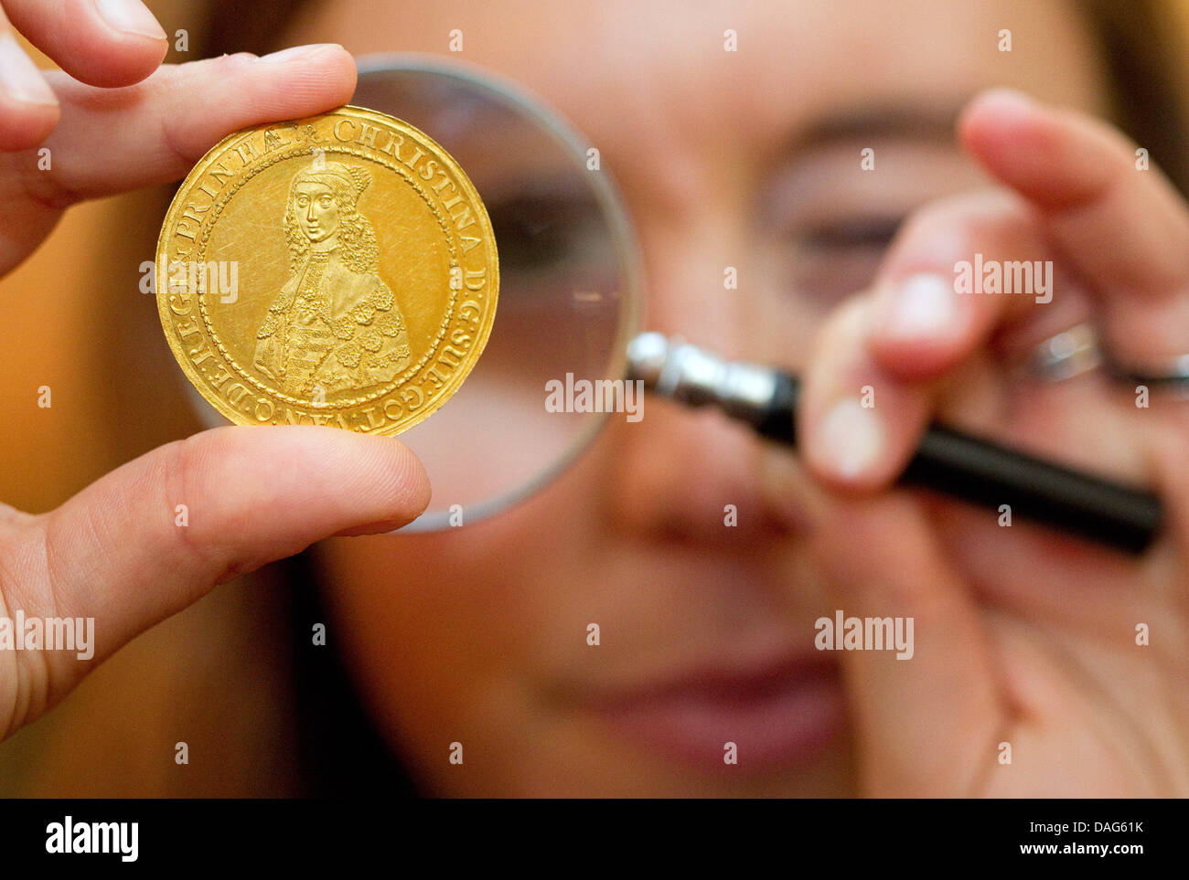 An auction house Kuenker employee examines a gold coin with a ...