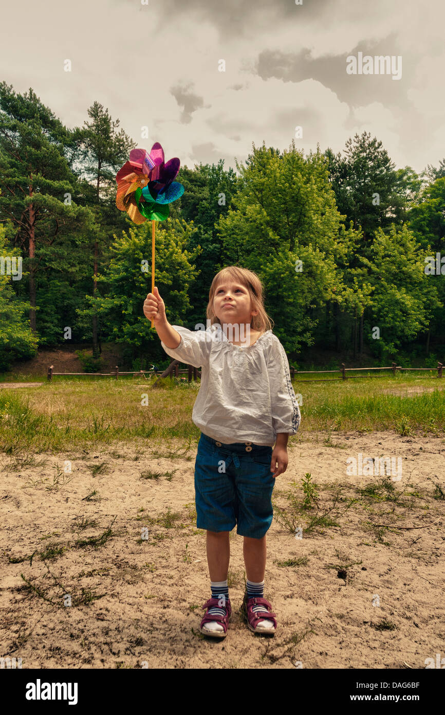 Girl observing her toy fan Stock Photo - Alamy