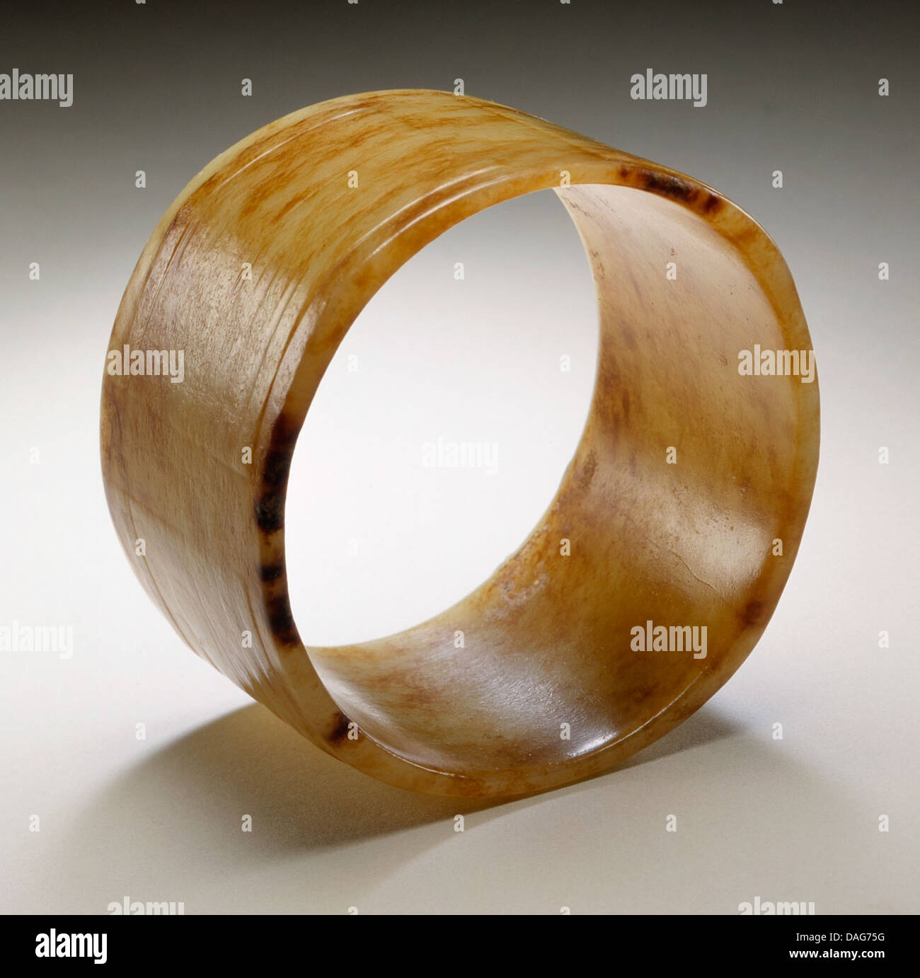 This ritual tube, known as a Cong, features carved masks and is part of ...